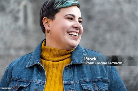 Portrait Of A Generation Z Non Binary Woman And Colored Short Hair With Toothy Smile Looking