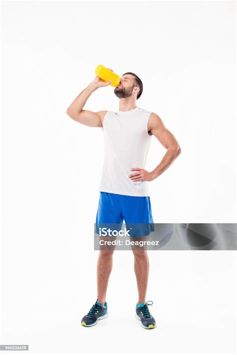 매력적인 왕성한 가혹한 낚시를 좋아하는 남자의 말투 그의 노란색 병에서 훈련 식 수 후 손 허리에 팔을 잡고 흰색 배경 위에 서 전장 초상화 남자에 대한 스톡 사진 및 기타