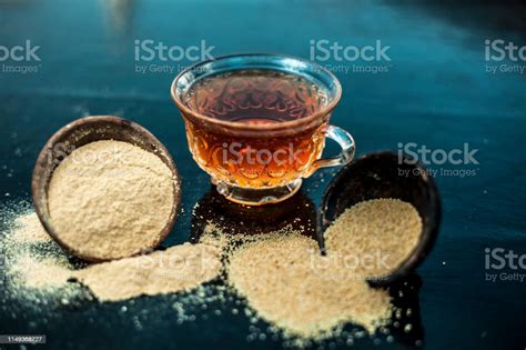 투명 유리 컵에 추출 된 초본 및 유기 플러스 유익한 해독 음료 또는 차를 가진 양 귀 비 종자 또는 Khus 또는 아편 양 귀 비 또는 빵 종자 양 귀 비의 나무 표면에