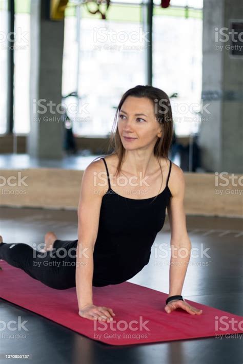 중년 여성이 피트니스 스튜디오의 매트에서 스트레칭과 요가 운동을 합니다 건강한 생활방식에 대한 스톡 사진 및 기타 이미지