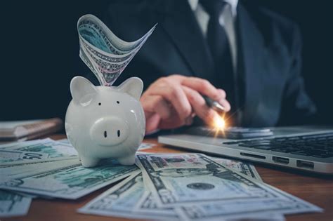 에너지 절약과 돈 개념 돈을 절약하는 사업가 개념 계산기를 사용하여 계산하고 돈을 쌓고 돈 지폐는 재무 계획을위한 메모와 함께 책상에 쌓입니다 가상현실에 대한 스톡 사진 및