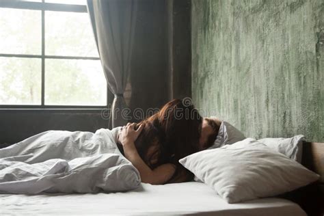 Пары в влюбленности имея секс в кровати под одеялом Стоковое Изображение изображение