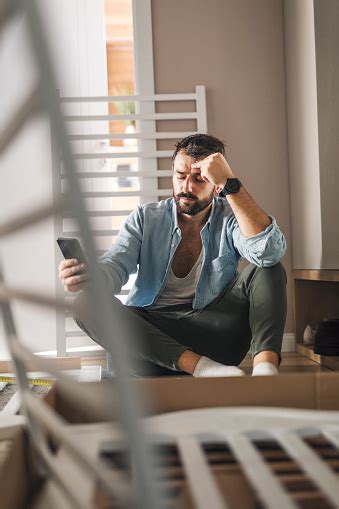 남자는 아기 침대를 조립하는 그를 돕기 위해 전화로 사람을 호출합니다 가구에 대한 스톡 사진 및 기타 이미지 가구 가족 교습 Istock