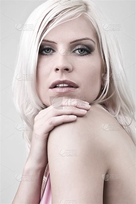 肖像迷人的金发女孩穿粉红色的上衣