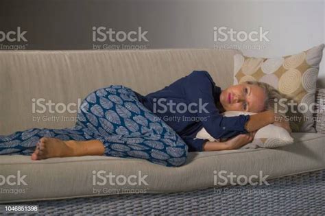 40 우울 및 불안 아름 다운 금발의 여 자가 우울증 느낌 좌절된 고통 외로운 거짓말 가정에서 소파 소파 사려 깊고 중 년 위기와 생활 문제에 잠겨있는 감정에 대한 스톡