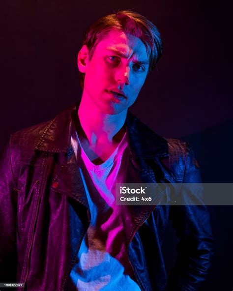 허리 업 2029세 어른 잘생긴 사람 금발 머리짧은 머리 백인 남성젊은 남성 앞에서 멀티 컬러 배경컬러 배경 착용 가죽 재킷티셔츠셔츠와 함께 손에 손에 그림자관능 20 29