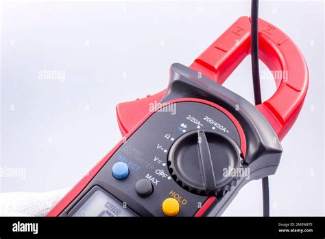 The Electrician Measures The Current In The Phase Wire With A Meter On A Gray Background Stock