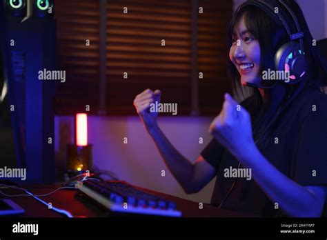 Female Cyber Hacker Gamer In Headphones Making Win Gesture After