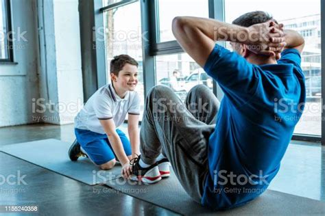 웃는 아들을 돕는 아버지는 피트 니스 매트에 앉아서 체육관에서 운동을 하 고 2명에 대한 스톡 사진 및 기타 이미지 2명 남성 남자 Istock