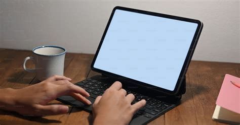 여성의 손의 자른 이미지는 나무 작업 책상에서 컴퓨터 태블릿을 사용하고 있습니다 사진 Unsplash의 온라인 데이트 이미지