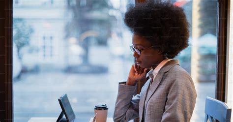 아늑한 카페에서 일하는 정장 옷과 안경을 입은 성공적인 비즈니스 여성 예쁜 아프리카 여자가 메모와 디지털 태블릿을 들고 테이블에 앉아 있다 사진 Unsplash의