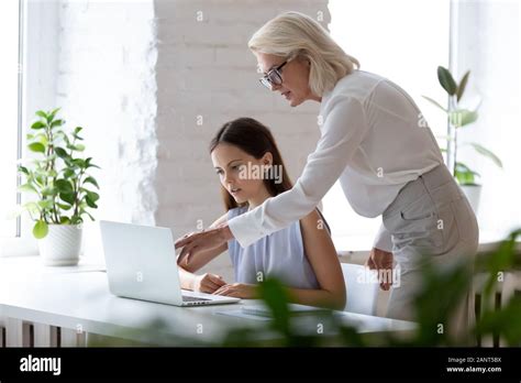 Middle Aged Female Boss Explaining Corporate Application To New Employee Stock Photo Alamy