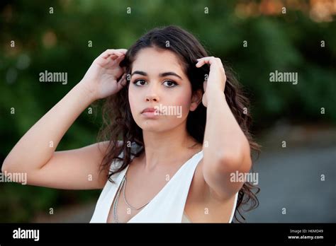 Beautiful Brunette Girl Relaxing In The Park Wiht Many Plants Of