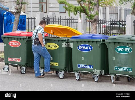 Man Throws Trash In The Dumpster With Inscription Stock Photo Alamy