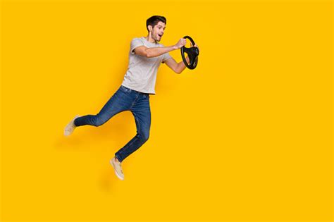 감동 브루넷 젊은 남자 점프 드라이브의 전신 사진 노란색 배경에 고립 된 티셔츠 청바지 신발을 착용 차에 대한 스톡 사진 및 기타 이미지 Istock