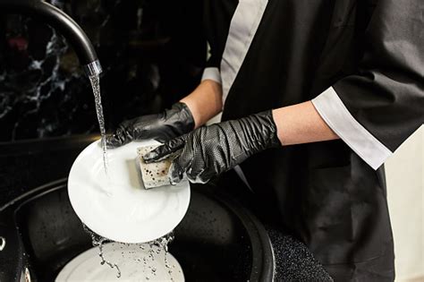 고무 장갑을 착용 한 전문 청소 서비스 회사 직원이 부엌의 싱크대에서 접시를 가까이서 씻고 소독하고 살균합니다 식기세척기에 대한 스톡 사진 및 기타 이미지 Istock