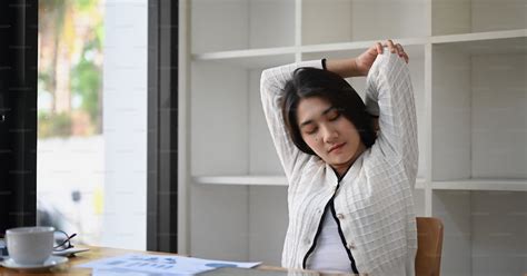 편안한 사무실 의자에서 휴식을 취하고 팔을 뻗는 사업가 사진 Unsplash의 태국 이미지