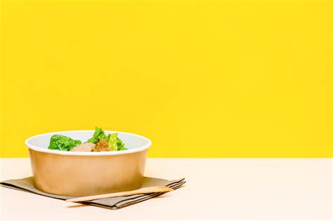 크래프트 종이 상자 친환경 상자 일회용 그릇 포장 둥근 용기 노란색 배경에 포크에 있는 건강 식품 점심 닭고기 채소 배달을 빼앗아 가십시오 환경 보호 복사 공간 0명에 대한