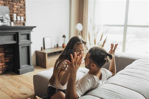 Het Jonge Romantische Paar Kust Thuis En Geniet Van Het Bedrijf Van Elkaar Stock Afbeelding