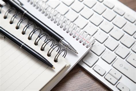 Premium Photo Pen And Notepad On The Computer Keyboard