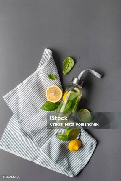 회색 배경에 과일 라임 레몬 바질 잎 줄무늬 수건이 있는 물 한 병이 놓여 있습니다 건강과 웰빙 개념 0명에 대한 스톡 사진 및 기타 이미지 Istock