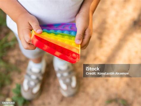 어린 소년은 사각 고무 만지작 장난감 팝 을 재생합니다 장난감이있는 야외 레크리에이션은 미세 한 운동 기술 개선을위한 것입니다 감각 지각에 대한 스톡 사진 및 기타 이미지