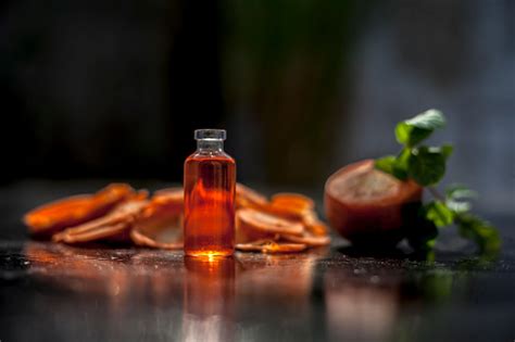 나무 표면에 박하 잎을 뿌린 갓 자른 당근과 작은 유리 병에 추출 된 필수 농도 또는 에센스와 함께 수평 샷 및 흐린 배경 개념에 대한 스톡 사진 및 기타 이미지 Istock