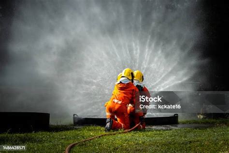 소방관 개념 화재로 싸우기 위해 물과 소화기를 사용하는 소방관 소방 훈련 훈련 중 호스와 물로 화재와 싸우는 소방관 2명에 대한 스톡 사진 및 기타 이미지 Istock