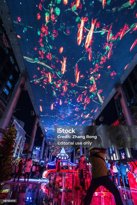 사람들은 거대한 Led 스크린이 중국 전통 스타일의 애니메이션을 보여주는 중앙 비즈니스 영역 의 공공 영역에서 크리스마스를 축하합니다 조명 장비에 대한 스톡 사진 및 기타