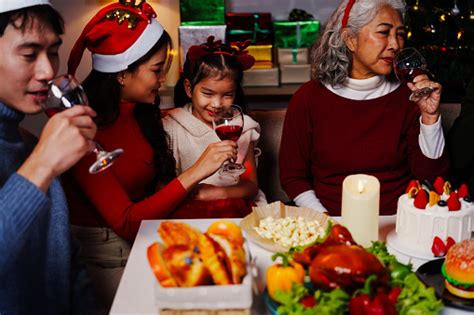 사랑하는 가족이 부모 자녀 조부모와 함께 크리스마스 파티를 위해 집에 모입니다 그들은 크리스마스와 새해를 기쁜 마음으로 축하하며 포도주 음식 음료를 나누고 선물을 교환한다