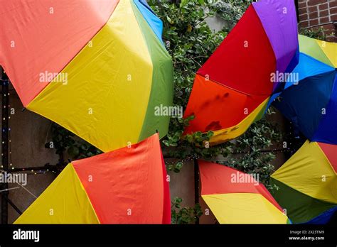 A Beautiful Cluster Of Rainbow Umbrellas On Display In An Alleyway