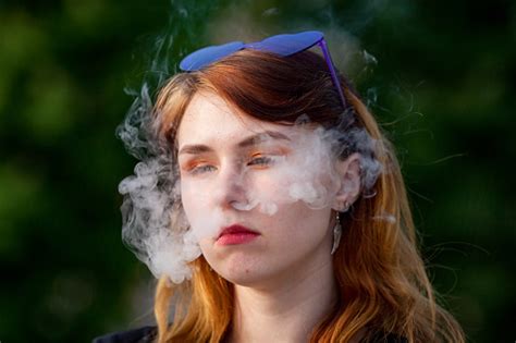 Vape 십대 여름에 는 거리에서 전자 담배를 그녀의 머리에 안경을 가진 젊은 예쁜 흰색 백인 소녀 나쁜 습관 18 19세에 대한 스톡 사진 및 기타 이미지 Istock