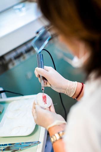 미용사는 미용실에서 영구 메이크업을 적용 할 준비를하는 동안 문신 기계에 색상을 넣어 Permanent Make Up에 대한 스톡 사진 및 기타 이미지 Permanent