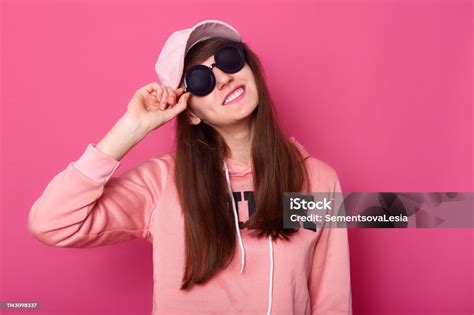 행복 한 미소 백인 갈색 머리 십 대에 세련 된 짧은 분홍색 까마귀 장미 모자 검은 색 안경 모자에 Hads를 보유 하 고 외출 하 고 친구 들과 시간을 보낼 준비 청소년