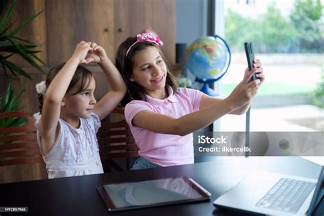 집에서 디지털 태블릿과 노트북 컴퓨터를 사용하는 두 명의 어린 자매 어린이를 위한 기술의 일상적인 사용에 대한 개념입니다 10