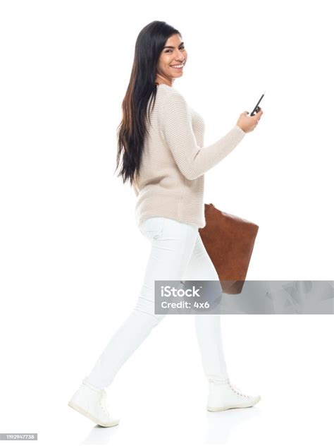 후면보기 뒤로 전체 길이 의 검은 머리 긴 머리 워킹 착용 스웨터 따뜻한 의류 시원한 태도 지갑 휴대 전화 스마트폰 문자 메시지 사용 검정 머리에 대한 스톡 사진 및 기타