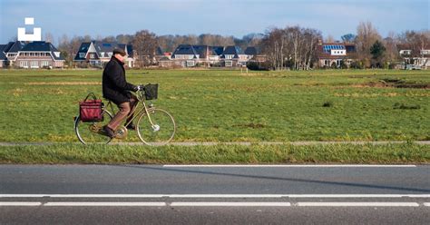 파랗고 하얀 하늘 아래 녹색 들판 근처에서 자전거를 타는 남자 사진 Unsplash의 무료 자전거 이미지