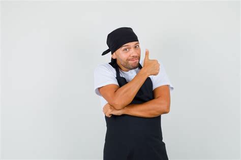 Free Photo Baker Man In T Shirt Apron Showing Thumb Up And Looking Glad