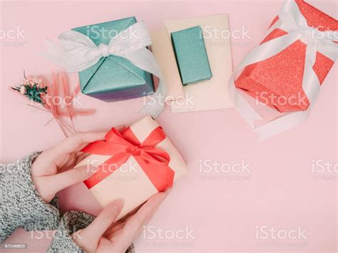 아름다움 여자의 손을 잡아 주고와 크리스마스 생일이 나 선물 상자와 핑크 파스텔 배경의 그룹과 새 해 축 하에 대 한 레드 리본 활 금 선물 상자 겨울에 대한 스톡 사진 및