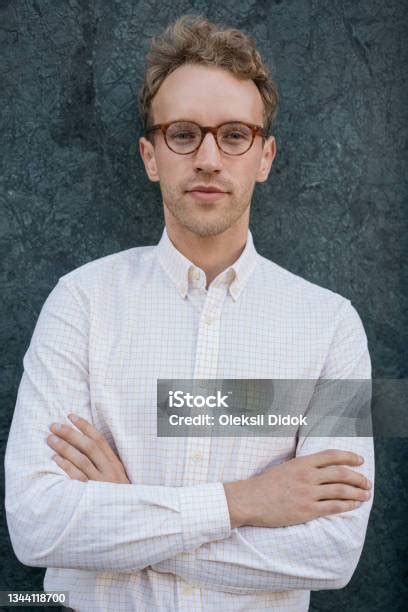 팔을 가진 자신감 있는 사업가가 질감이 있는 벽 근처에 서 있었다 셔츠를 입은 패션 모델 카메라를 바라보는 세련된 안경 남자 사업가에 대한 스톡 사진 및 기타 이미지