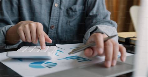 사무실 테이블에 재무 문서 그래프 다이어그램 및 계산기가 있는 계산기 및 랩톱 컴퓨터에서 작업하는 비즈니스 여성 또는 회계사 재택 근무 사진 Unsplash의 태국 이미지