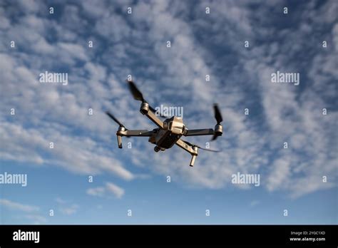 photograph of a dji drone centered within the frame flying in the sky