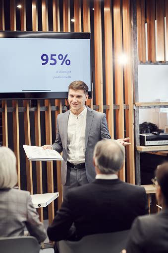청중 앞에 서서 비즈니스 컨퍼런스에서 성공적인 마케팅 사례를 제시하는 정장에 자신감있는 젊은 사업가미소 경영자에 대한 스톡 사진 및 기타 이미지 Istock