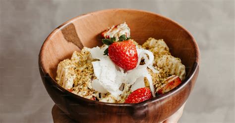 딸기와 함께 시리얼 한 그릇을 들고 있는 사람 사진 Unsplash의 그릭 요거트 이미지