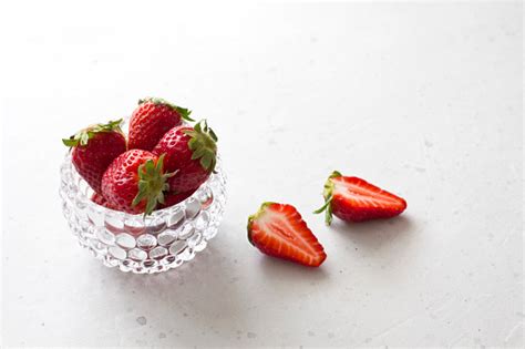 유리 둥근 그릇에 아름 다운 빨간 딸기 밝은 흰색 콘크리트 배경에 딸기 소박한 스타일 딸기 반을 잘라 수평 맨 위 보기 텍스트에 대한 복사 공간 0명에 대한 스톡 사진 및