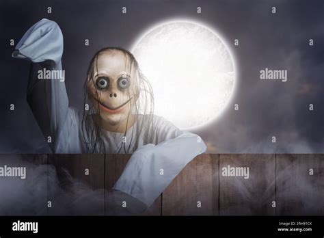 Scary Momo Standing Behind The Wooden Fence With A Night Scene