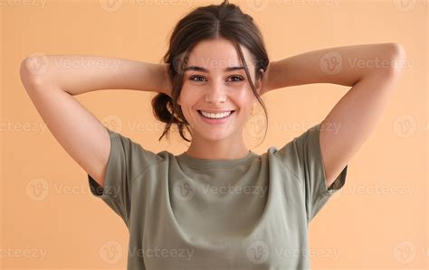 Smiling Young Woman With Brown Hair Poses Confidently Against A Warm