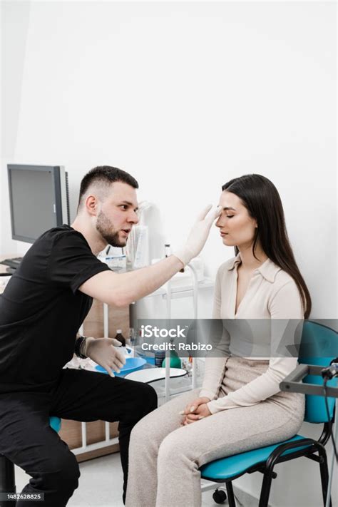 코 성형술은 코의 모양을 바꾸고 호흡을 개선하기 위해 코 수술을 재구성합니다 이비인후과 의사가 중격 성형술 전에 코를 만지고 진료소에서 여자 환자와 상담하고 있습니다 여자에