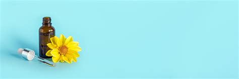 파란색 배경에 거짓말 유리 파이펫과 노란색 꽃 오픈 갈색 드롭퍼 병에 에센셜 오일 컨셉 트인 내츄럴 유기농 미용 화장품 제품 복사 공간 배너 갈색에 대한 스톡 사진 및 기타