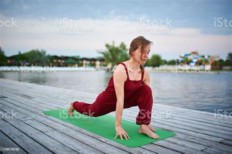 아름다운 젊은 여자 연습 요가 아사나 비라 바드라사나 1 전사 는 호수 근처의 나무 갑판에 1 포즈 단정 갑판에 대한 스톡 사진 및 기타 이미지 Istock